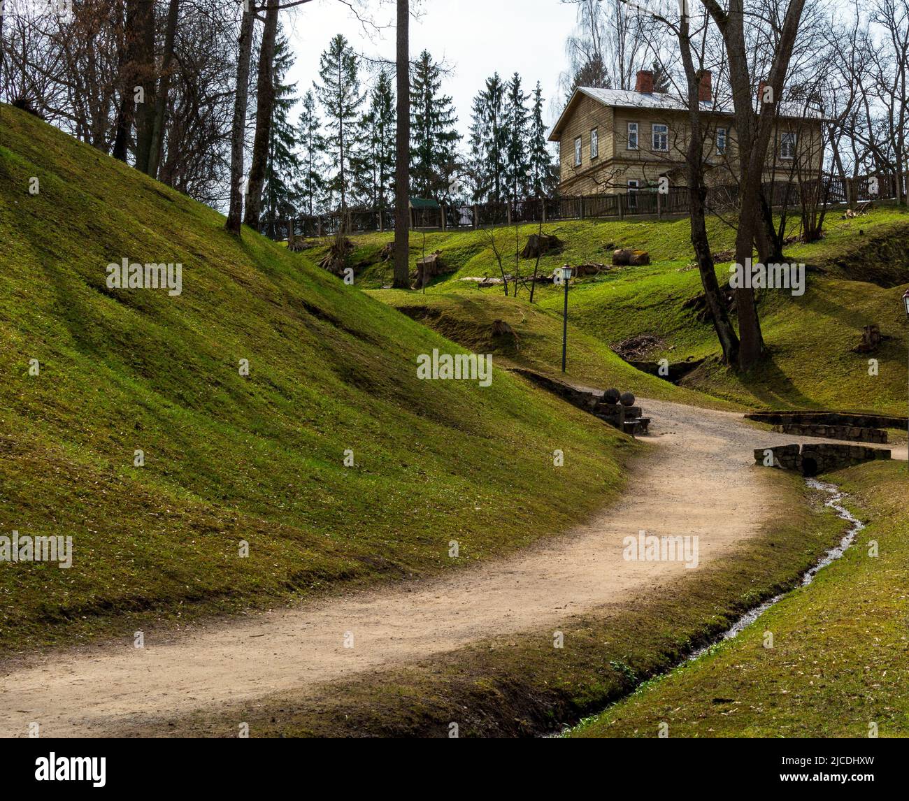 Countryside old wooden house on green hill with yellow sand path ...
