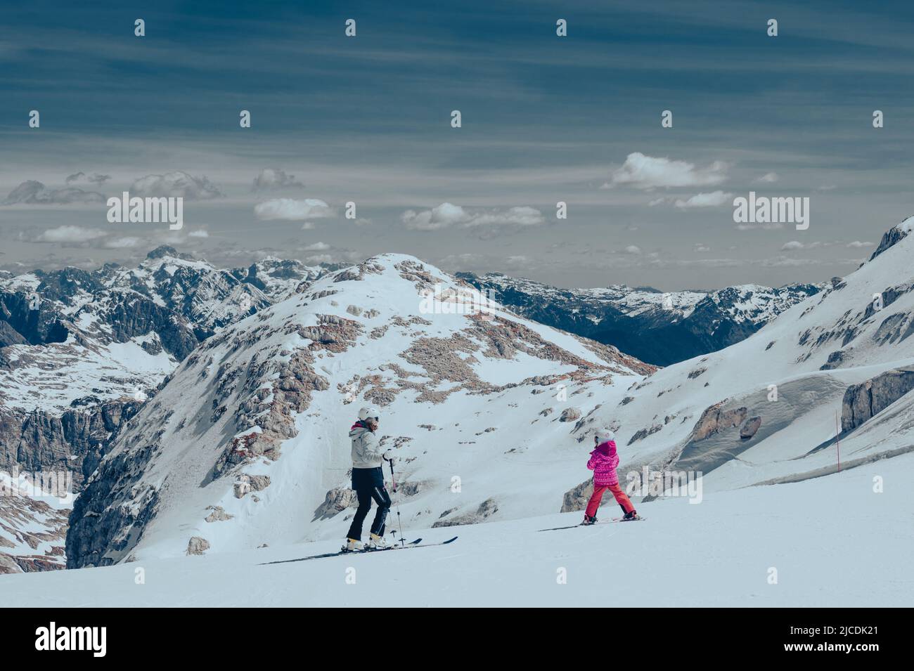 Mother and daughter having fun and learning skiing making first steps on a ski winter resort at ...