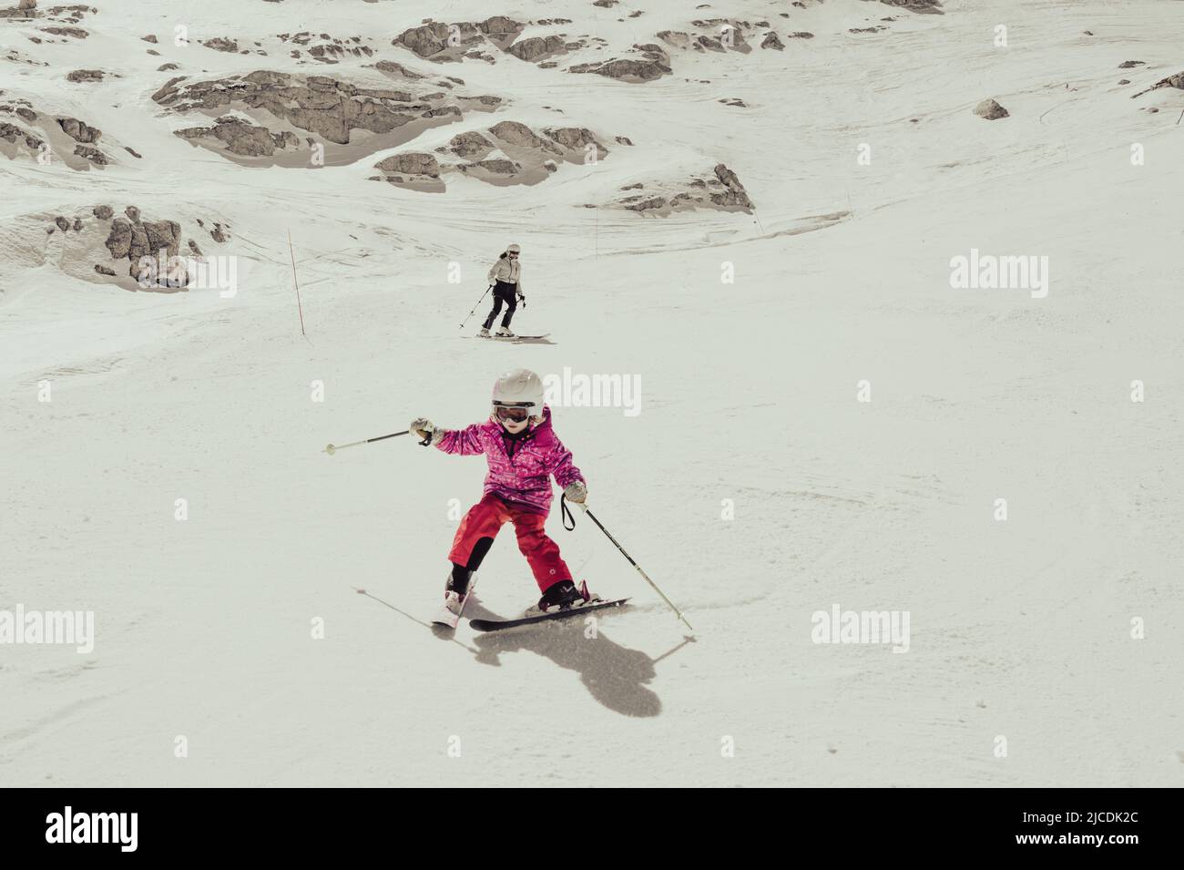 Mother and daughter having fun and learning skiing making first steps ...