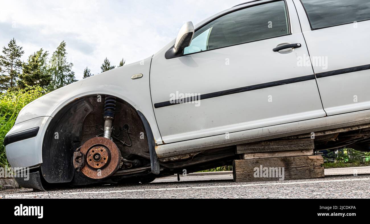 Abandoned car on a block of wood, wheels removed Stock Photo - Alamy