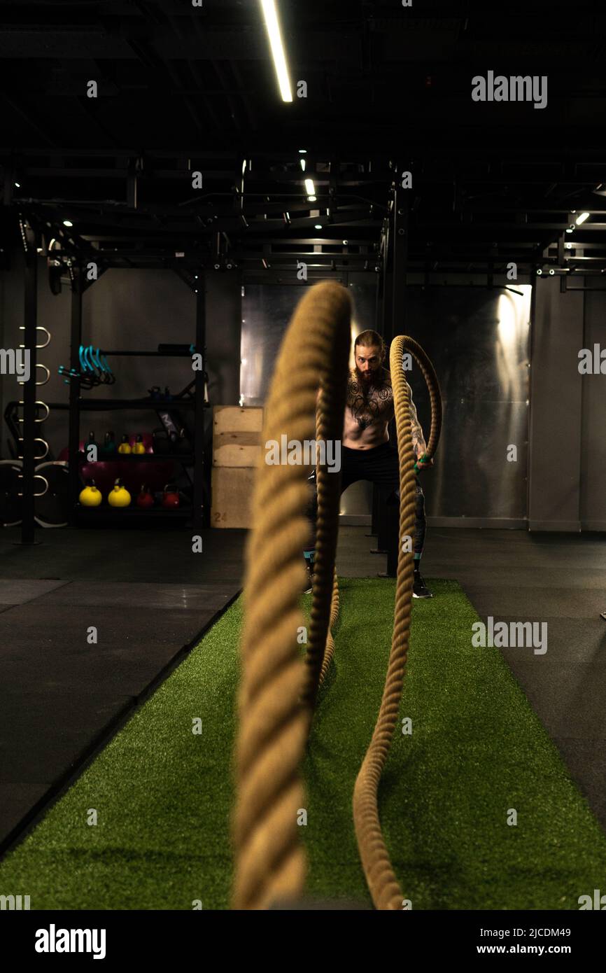 Rope training man warehouse fitness gym muscular exercising exercise ...