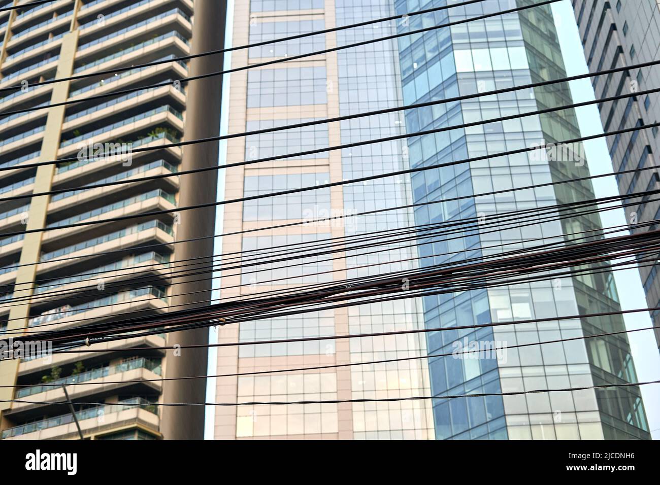 Electric wiring in front of a facade of a modern building in Bangkok ...