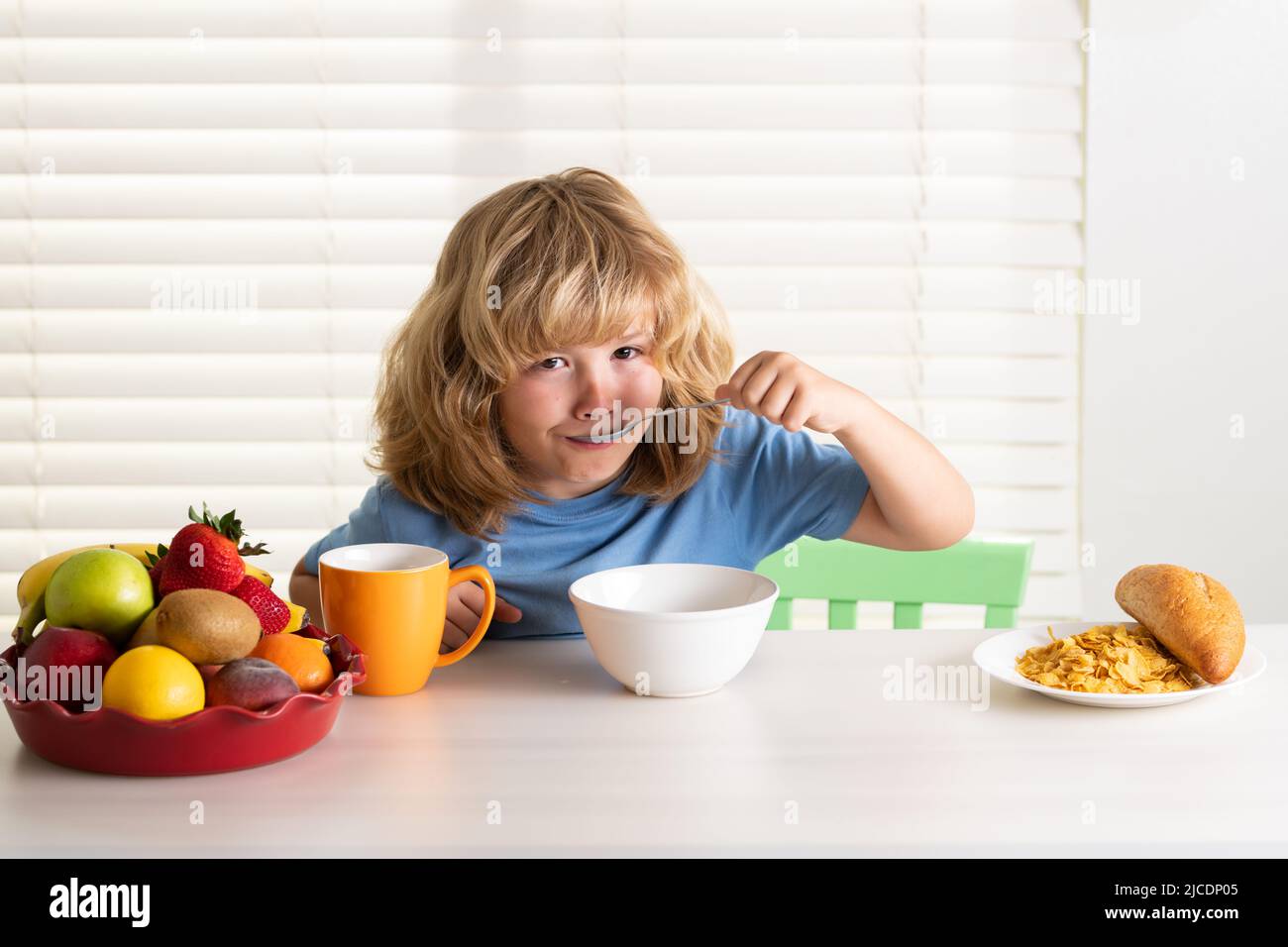 Portrait of preteen child eat fresh healthy food in kitchen at home ...