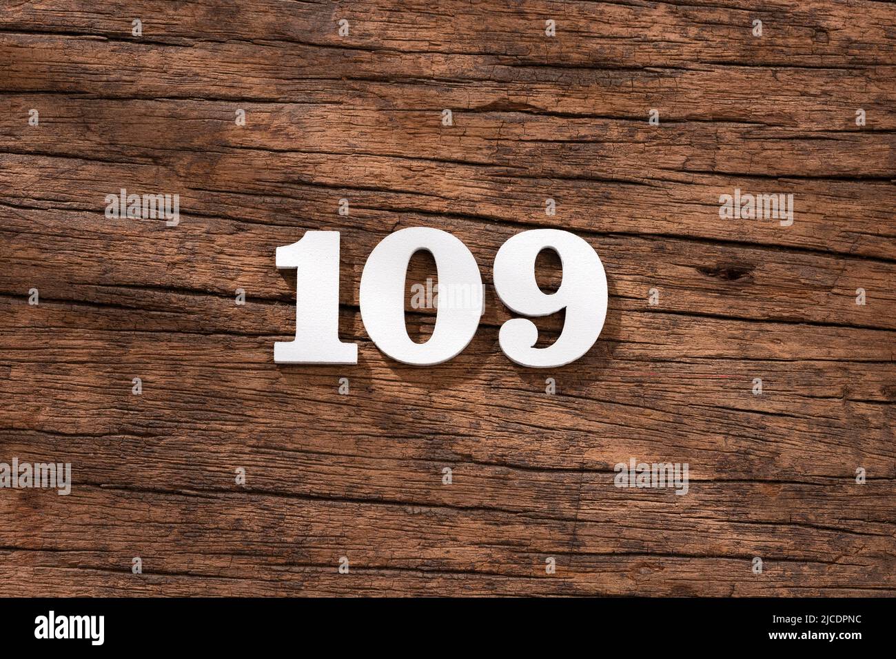 Number 109 - piece on rustic wood background Stock Photo - Alamy