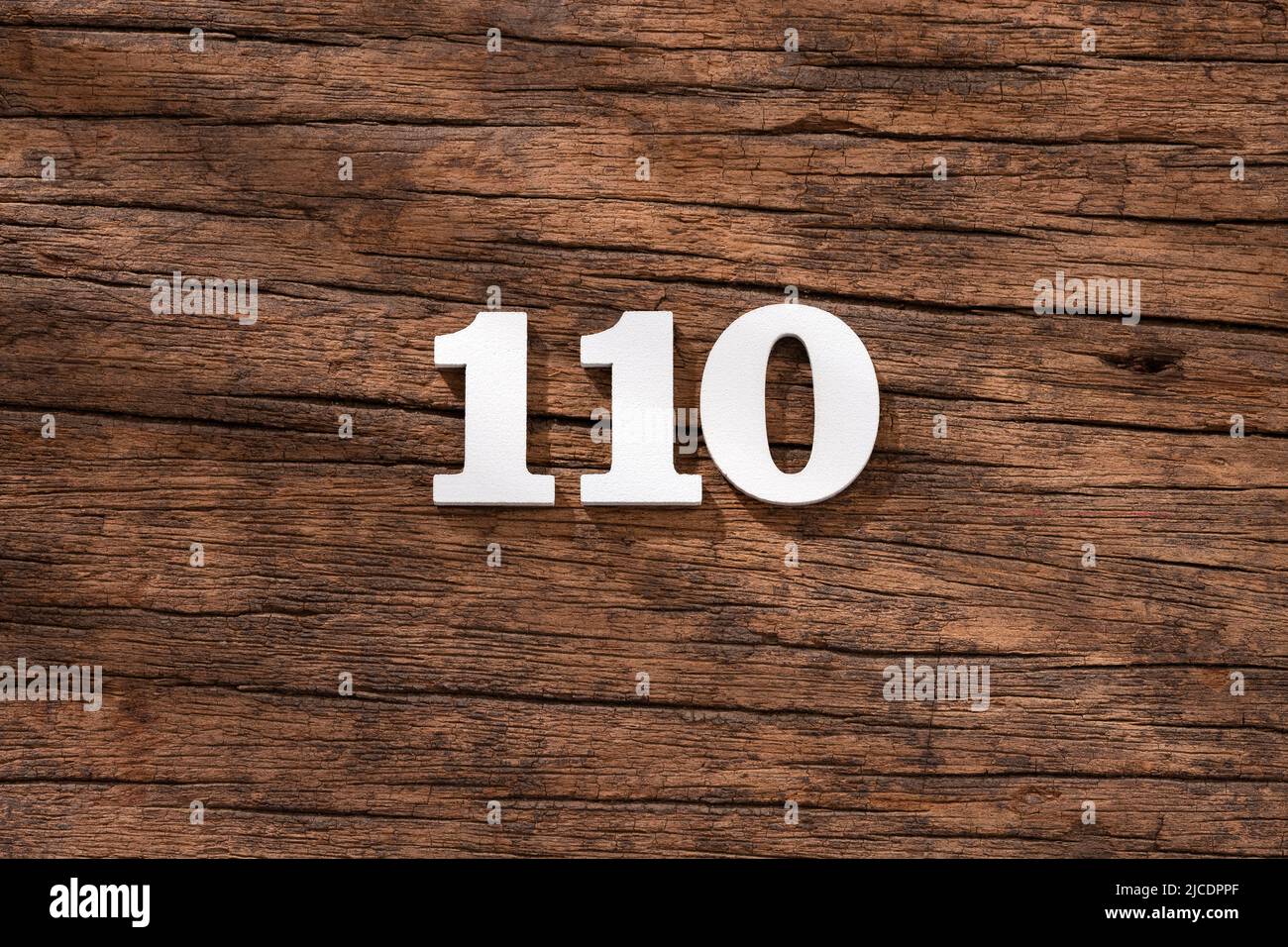 Number 110 in wood, isolated on rustic background Stock Photo - Alamy