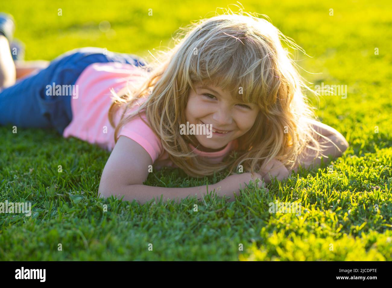 Spring child face. Smiling child boy with grass background. Portrait of ...