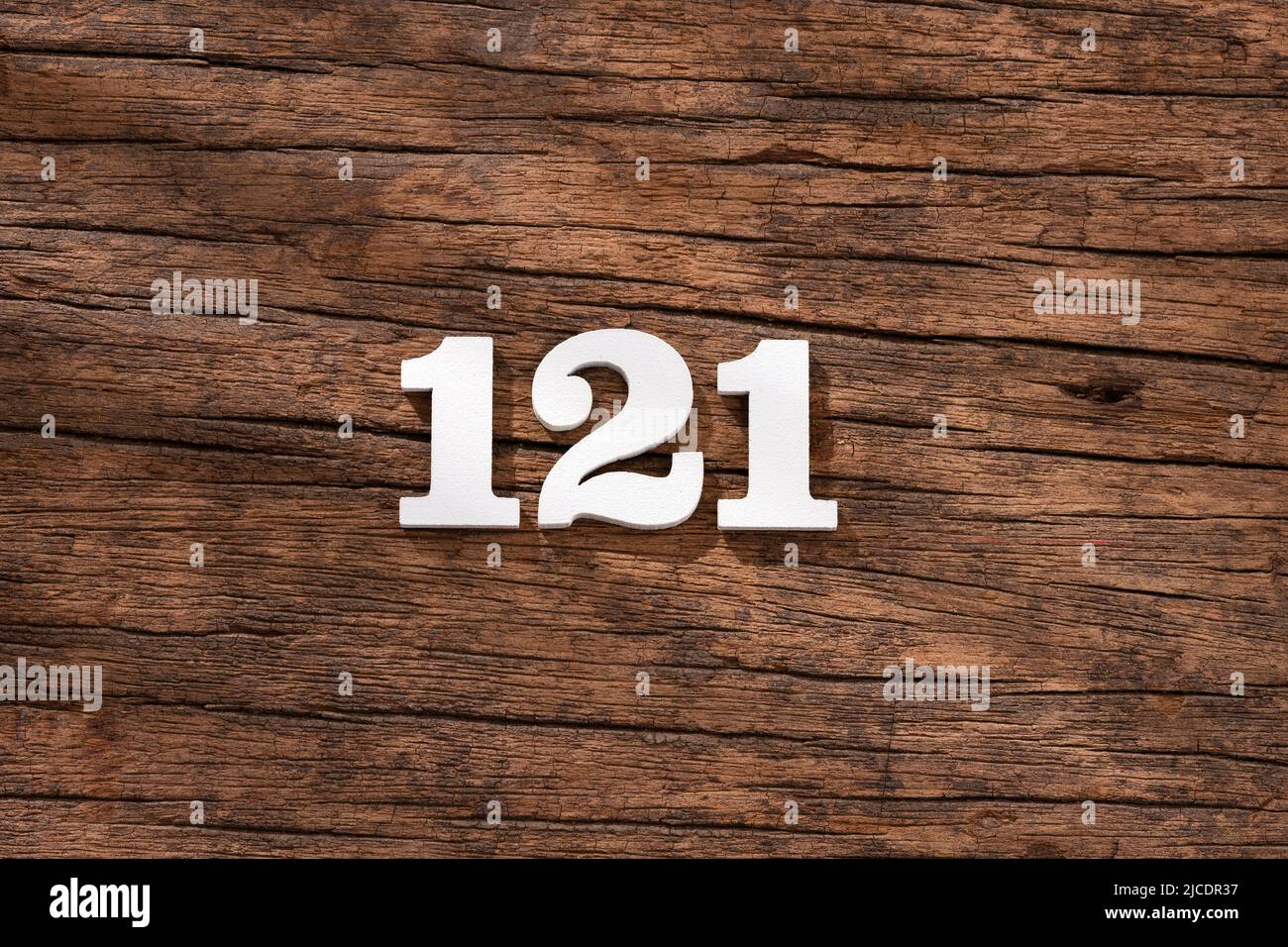 Number 121 - piece on rustic wood background Stock Photo - Alamy