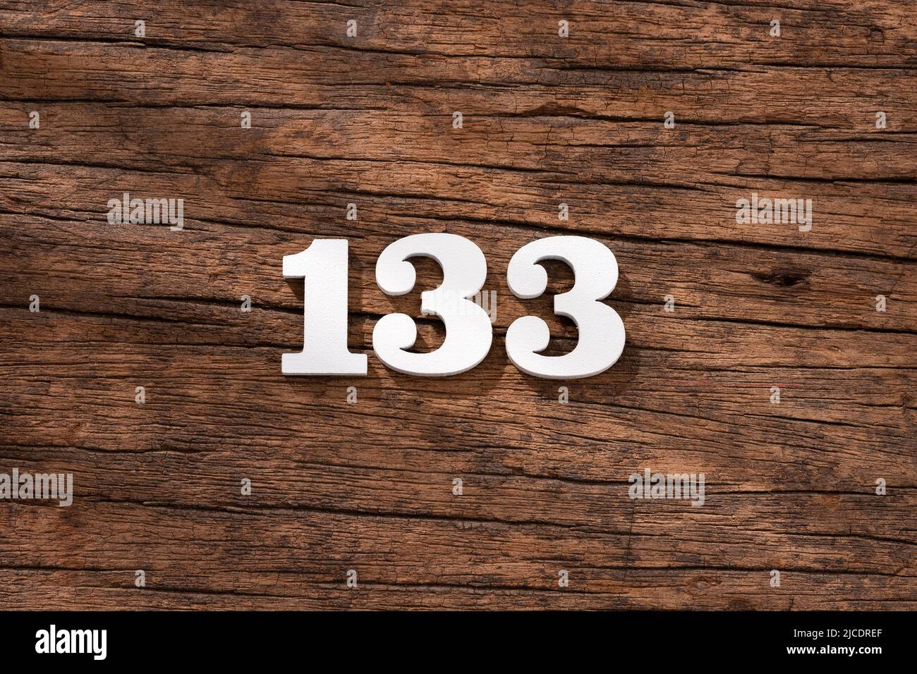Number 133 - piece on rustic wood background Stock Photo - Alamy