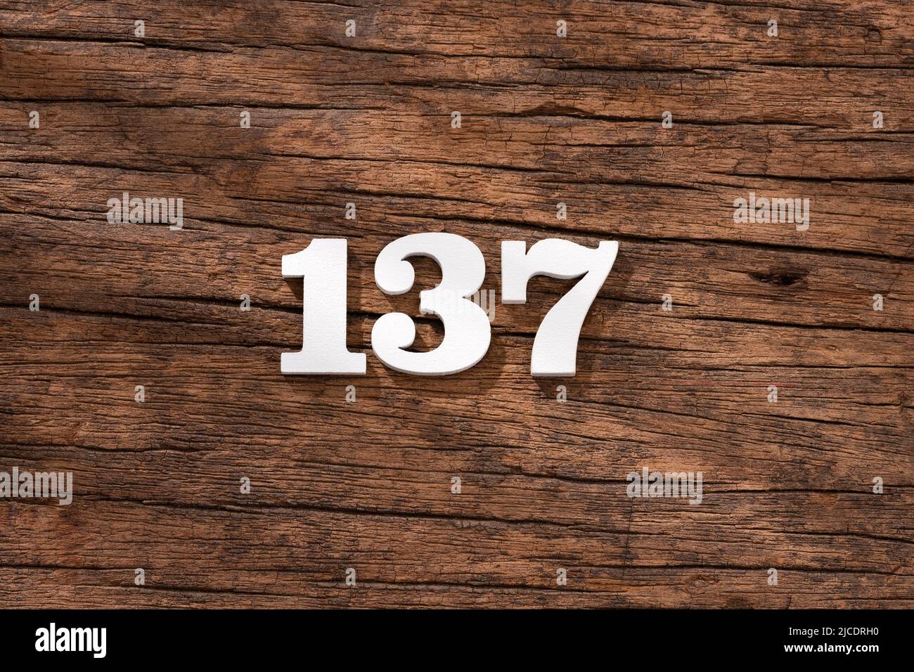Number 137 - piece on rustic wood background Stock Photo - Alamy