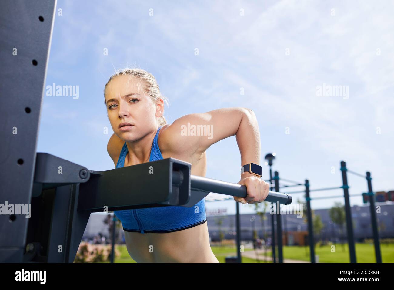 Portrait of young muscular woman with smartwatch practicing band ...