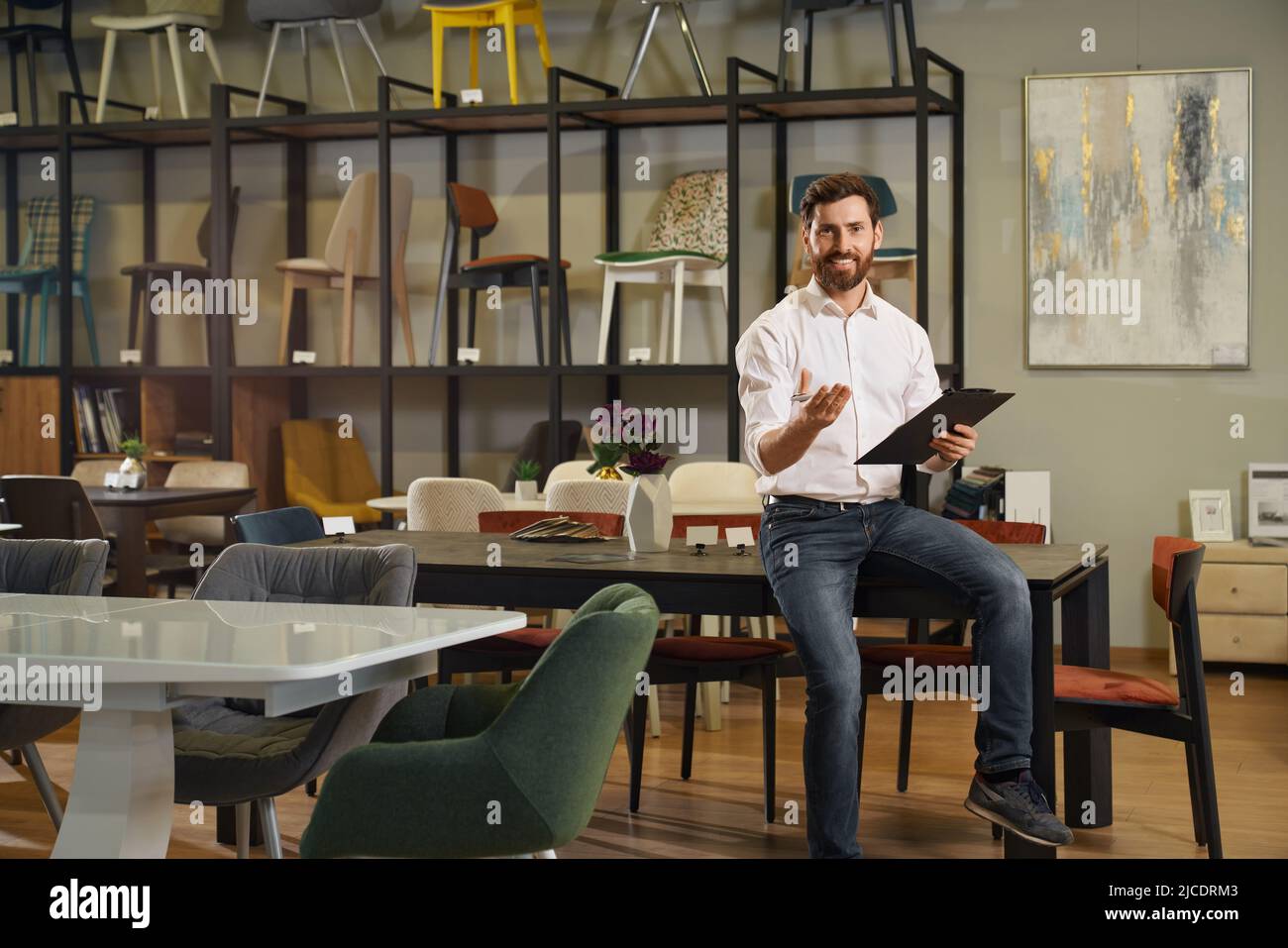 Front view of brunette male with beard designing in furniture store ...
