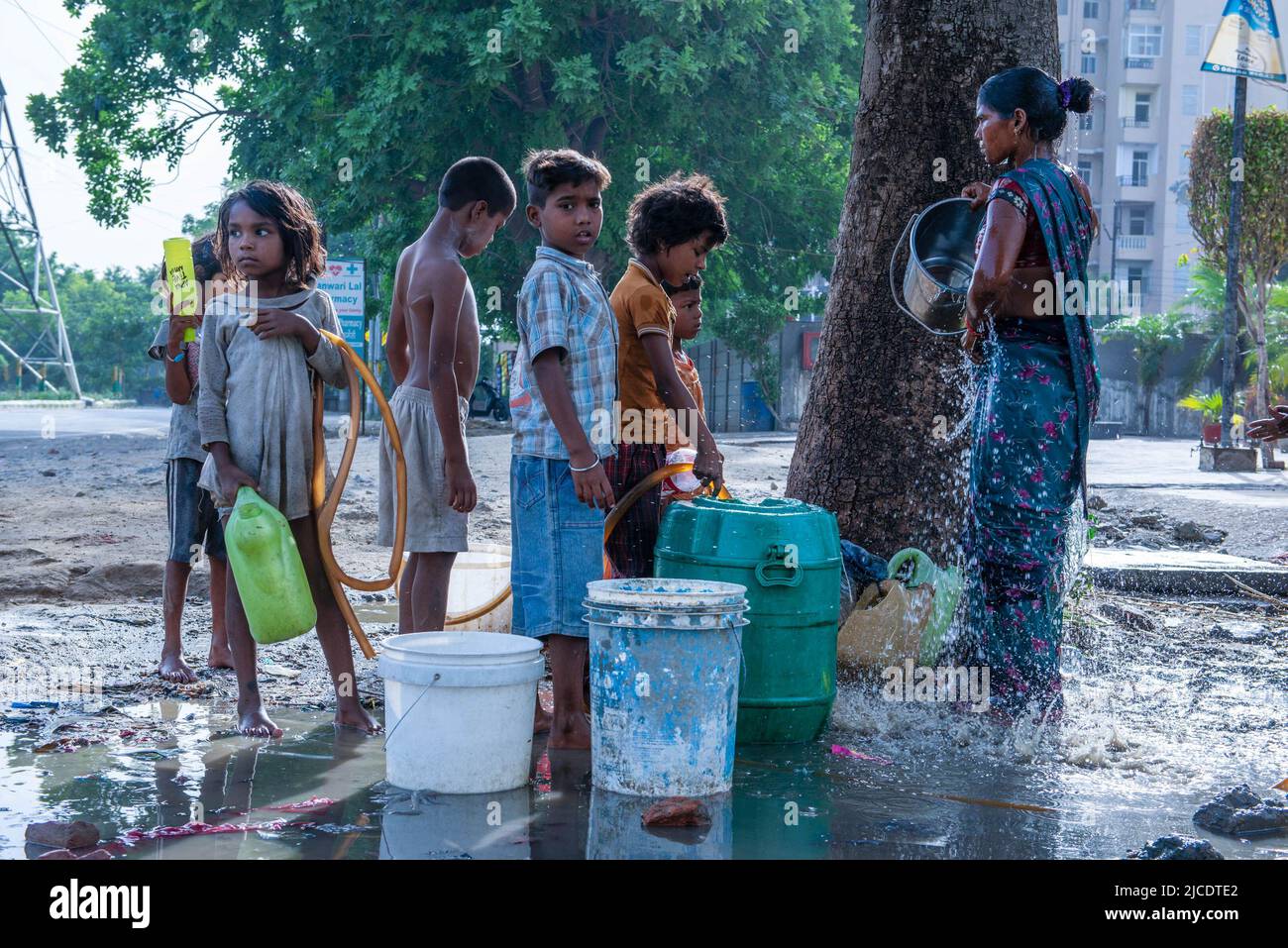 A child fills a container with water from a roadside water pipeline ...