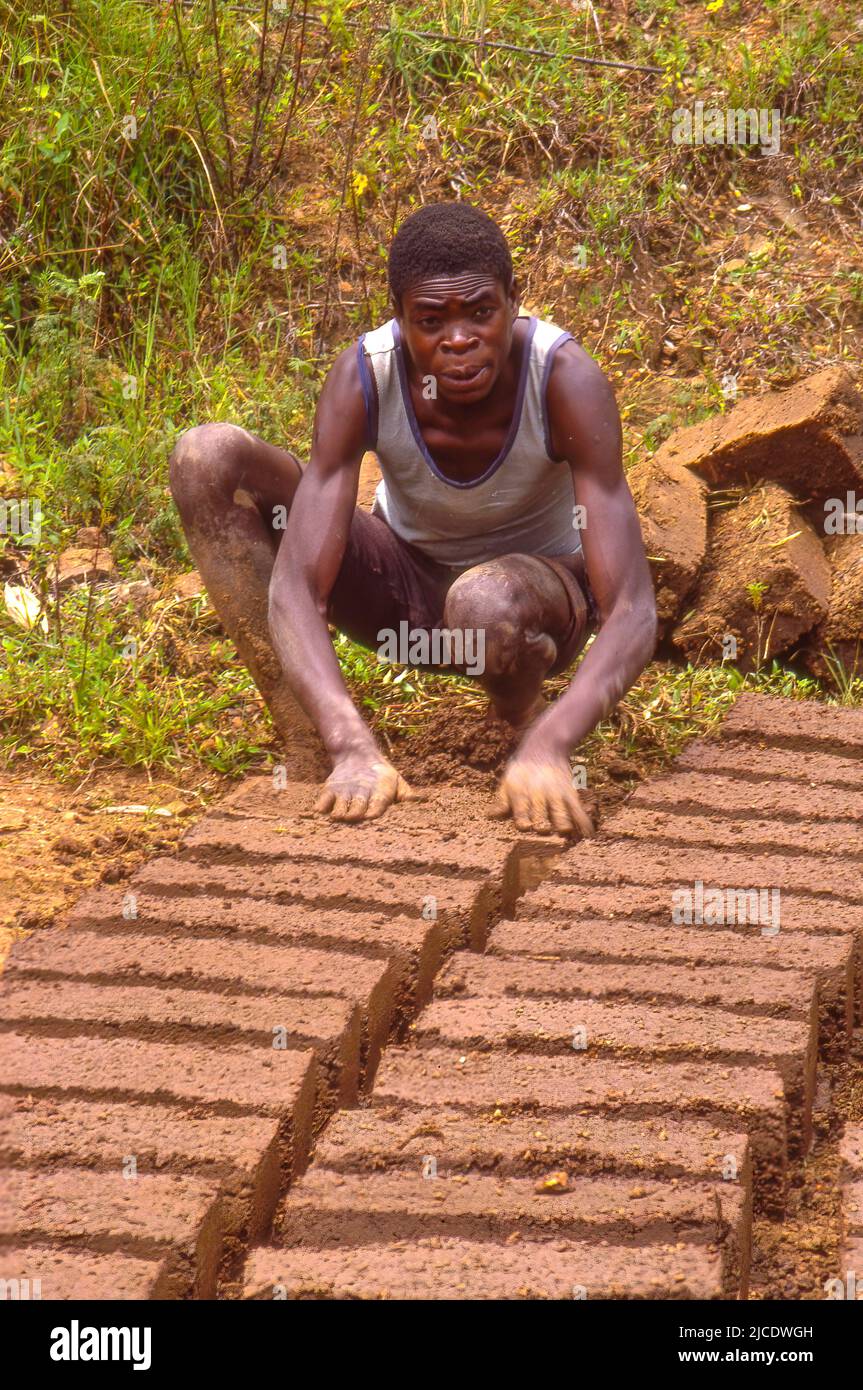 A brickmaker displays his wares alongside a road in Rwands. Bricks are ...