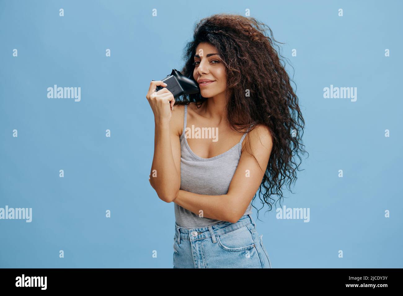 ONLINE GAME AD CONCEPT. Smiling beautiful curly Latin lady hold game ...