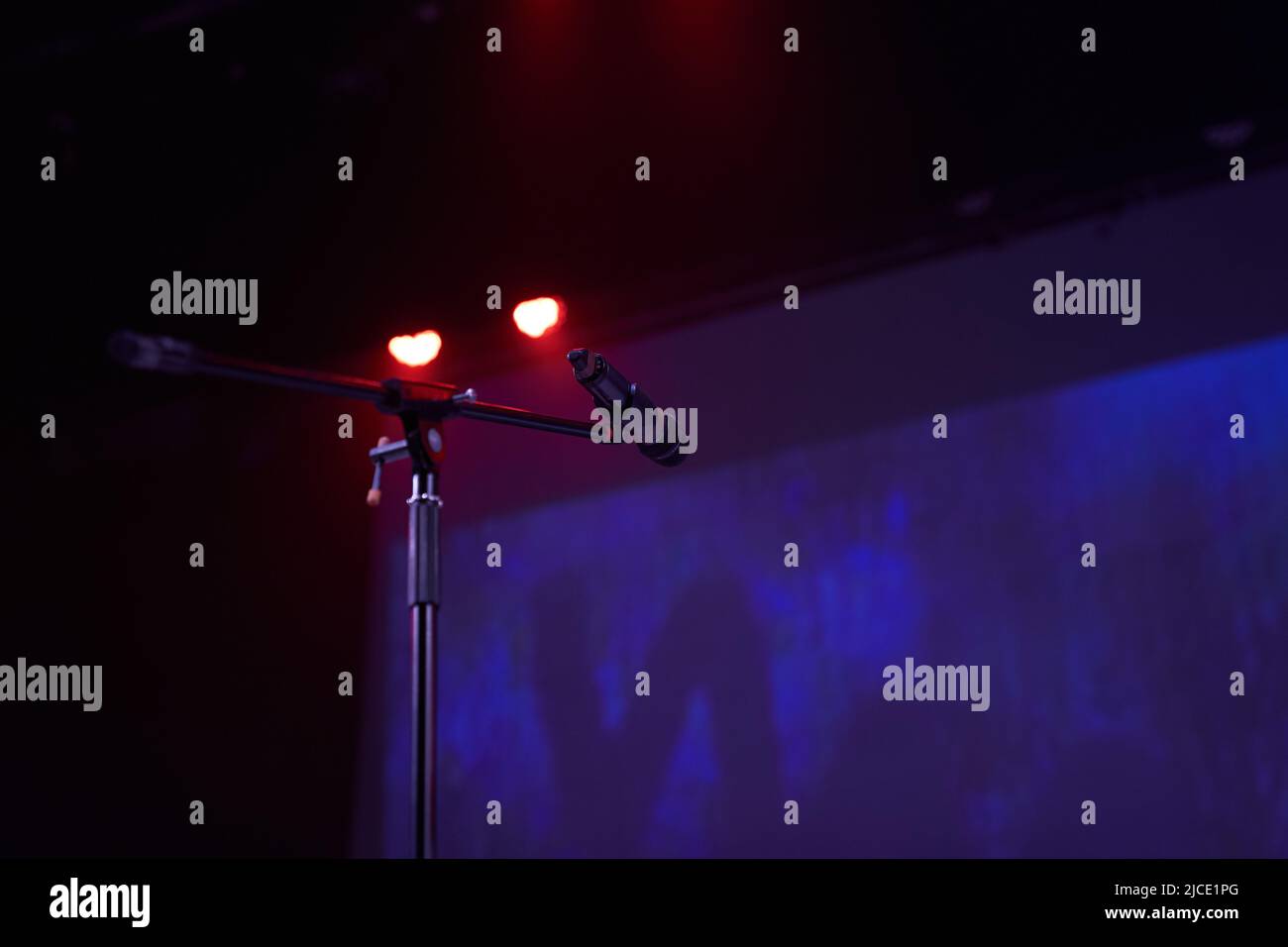 Professional stage microphone in the bright spotlight in the dark ...