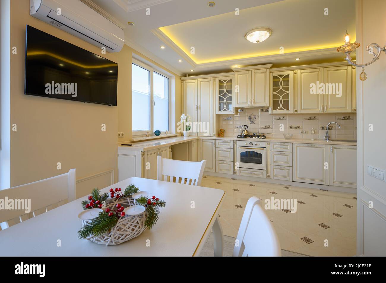 Classic white and beige large kitchen with dining table in studio ...