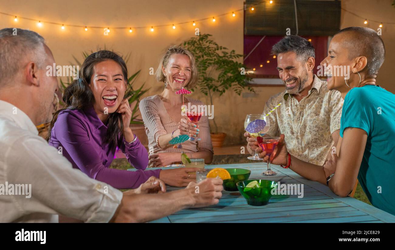 Cheerful friends drinking cocktails. Mature people having fun summer ...