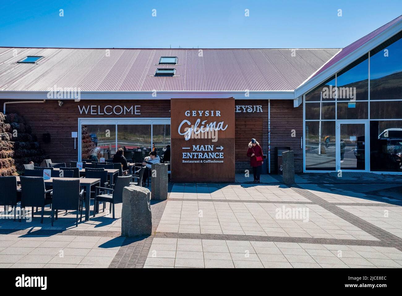 Tourists relaxing at Restaurant Geysir Glima against blue sky during ...