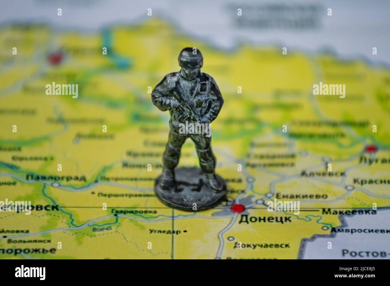 Metal figurine of a soldier on the background of the map of Ukraine ...