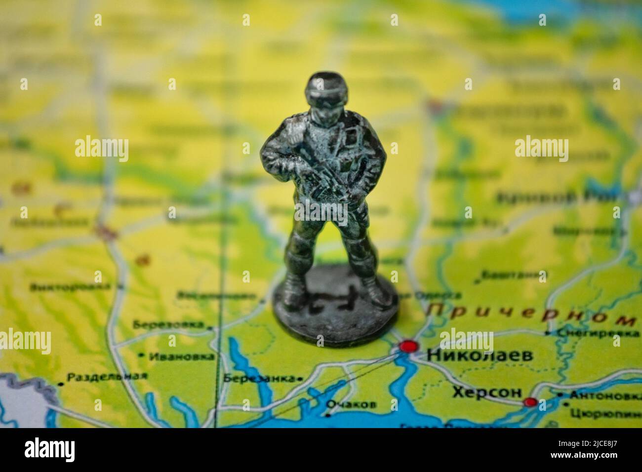 Metal figurine of a soldier on the background of the map of Ukraine ...