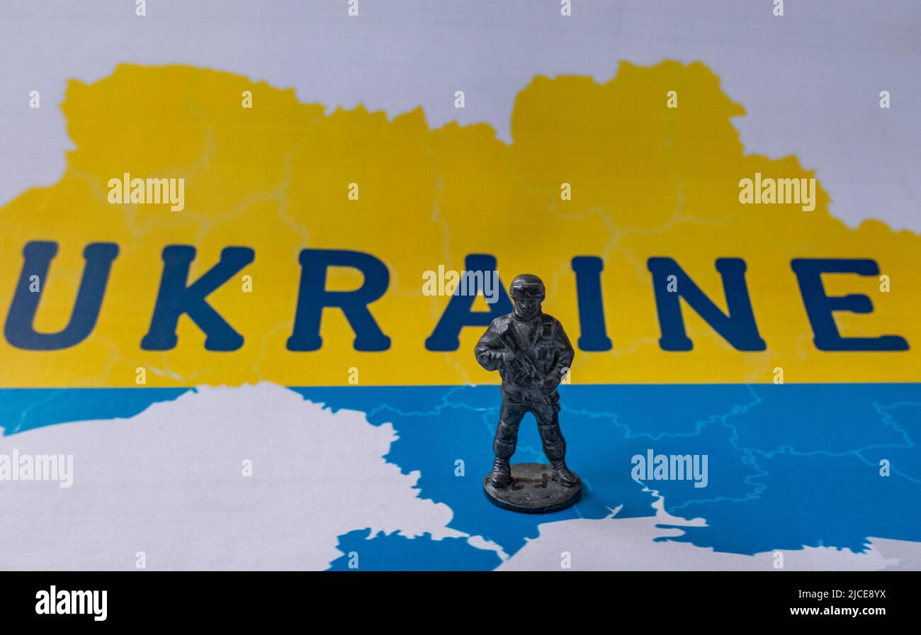 Metal figurine of a soldier on the background of the map of Ukraine ...