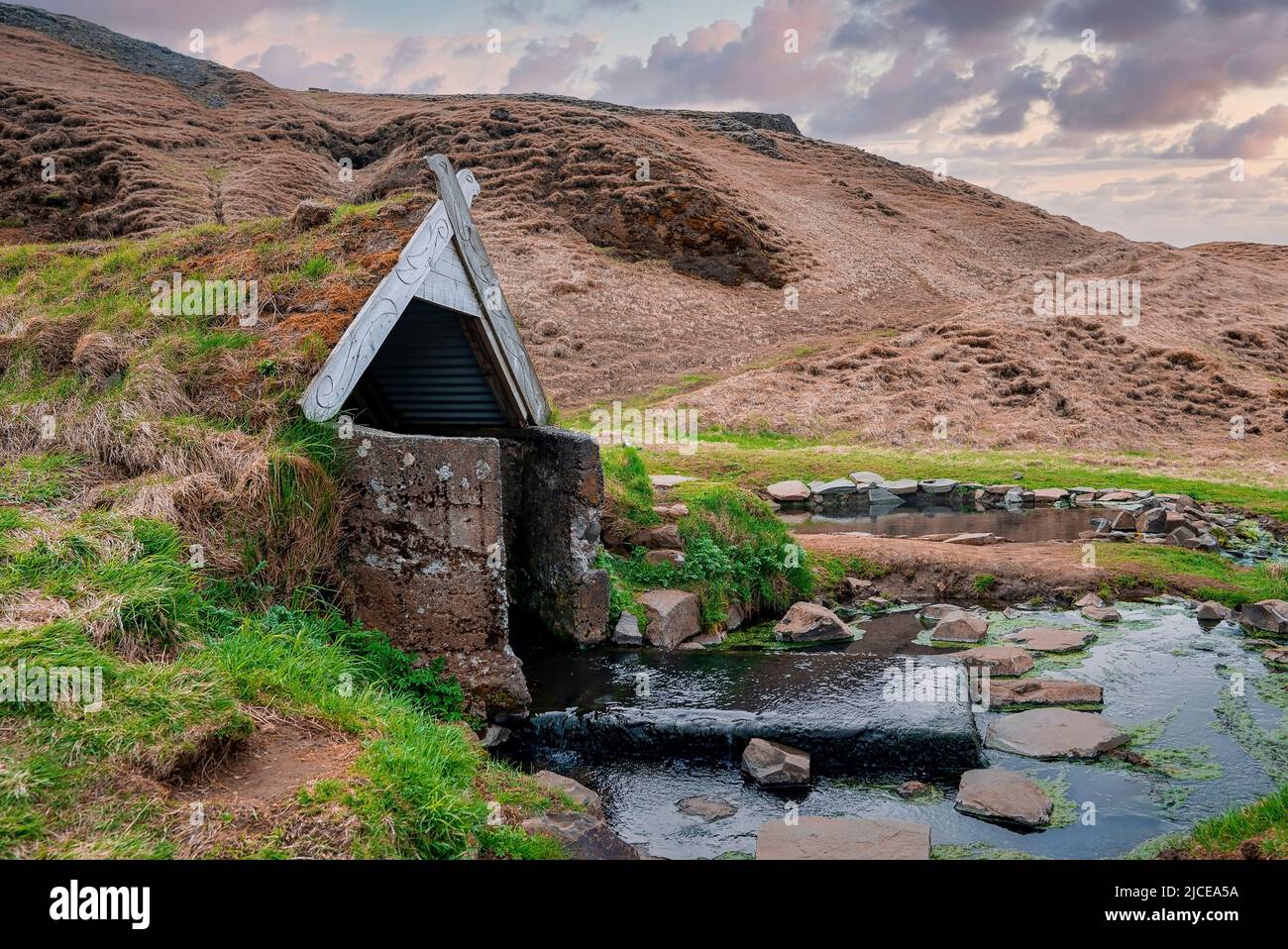 Geothermal hot spring and Turf house in Hrunalaug on mountain against ...