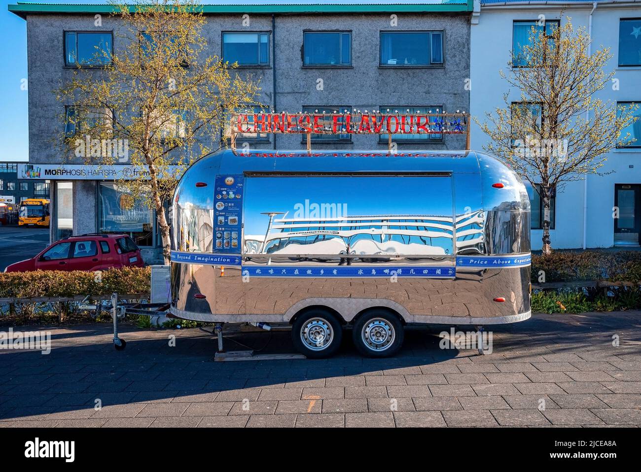 Chinese food trailer parked against building on street during sunny day ...