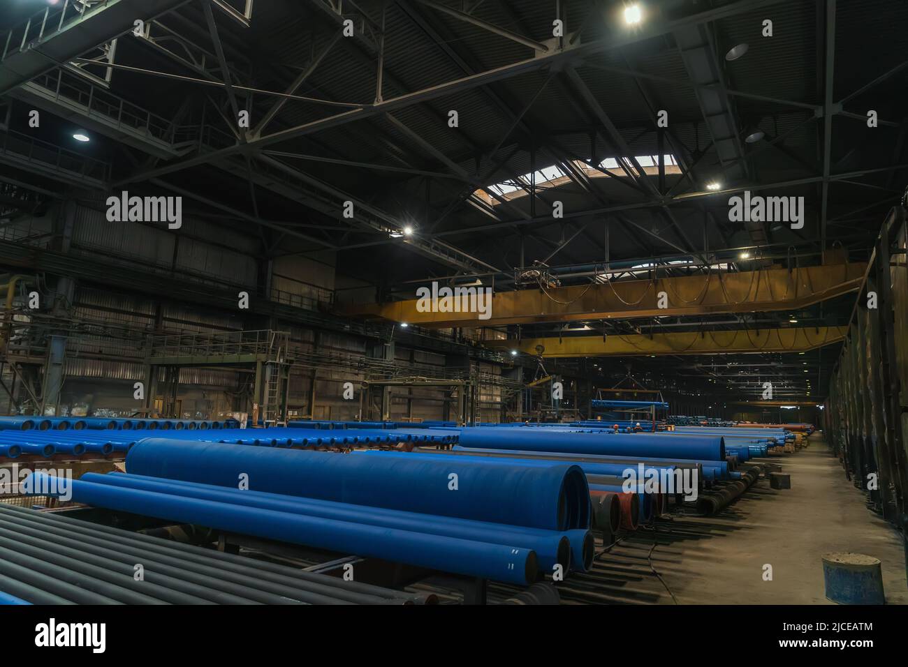 Group of blue metal pipes for water in metallurgical factory warehouse ...