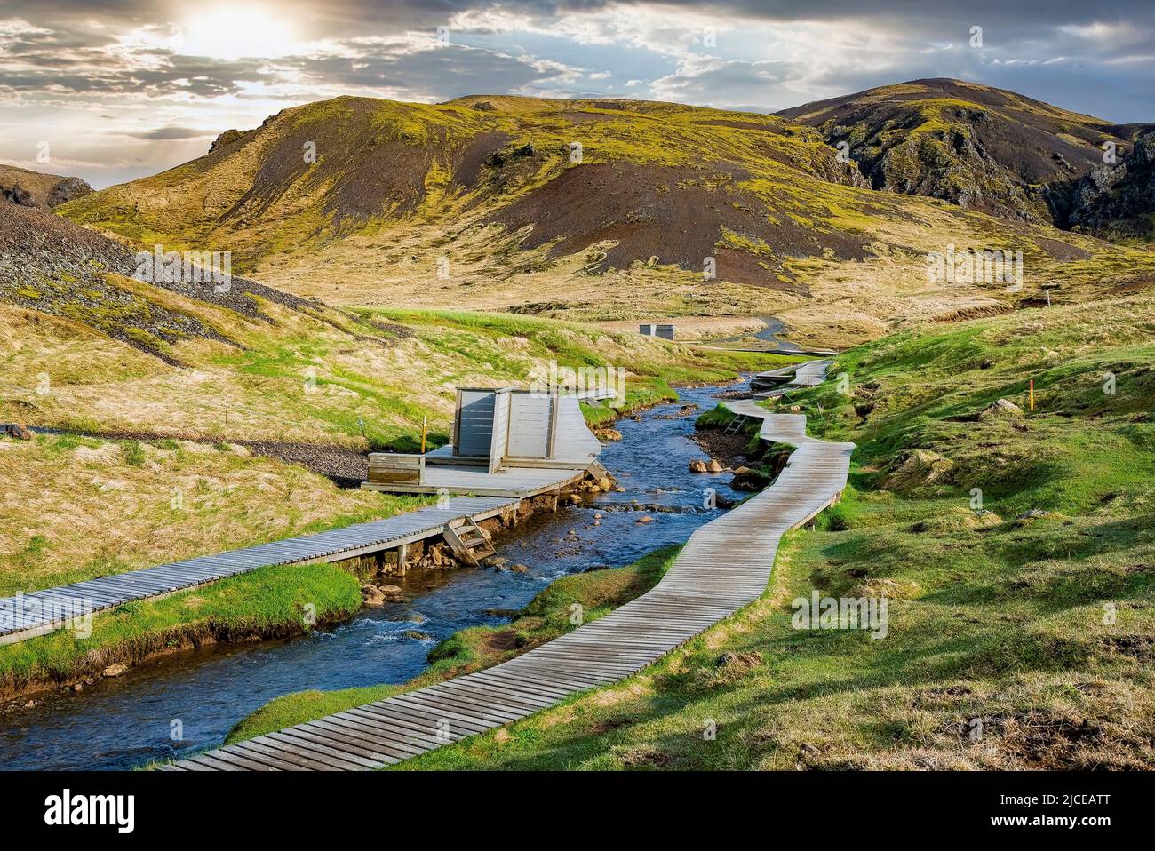 Wooden boardwalk and changing room by geothermal bath stream in ...