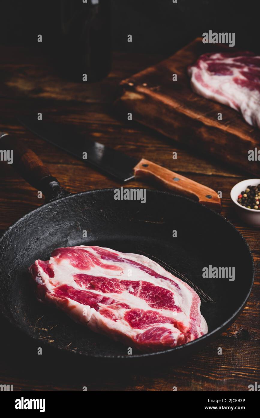 Raw pork neck steak in cast iron skillet Stock Photo - Alamy