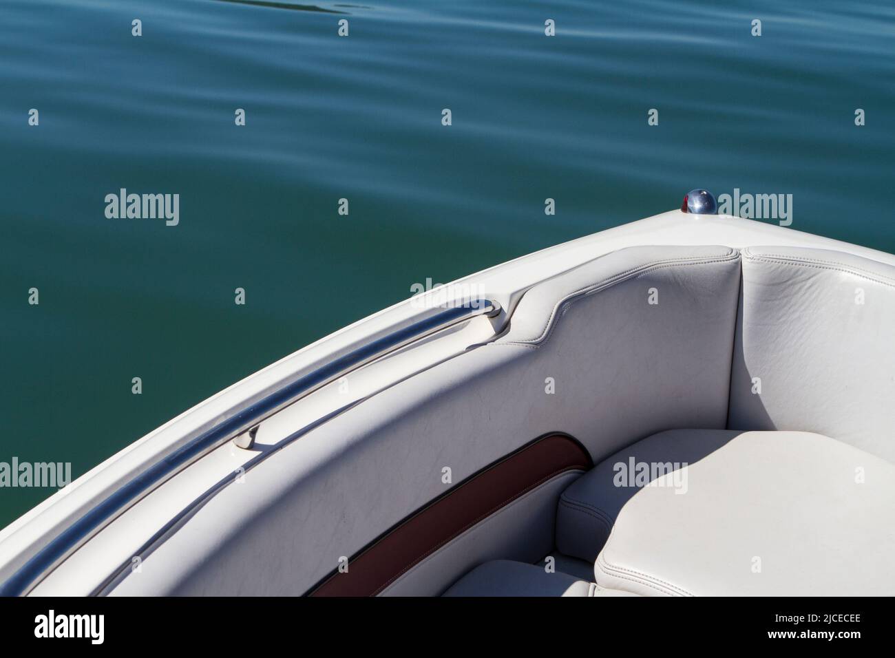 Closeup image of bow of wake board and water ski boat against calm ...