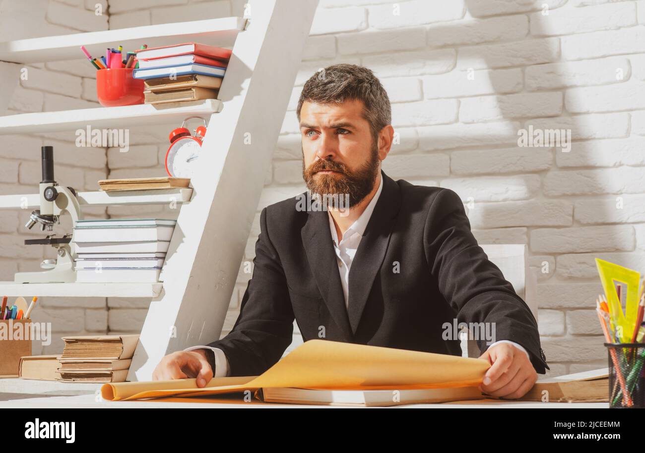 Teacher working at desk. Portrait of thinking male teacher, professor ...