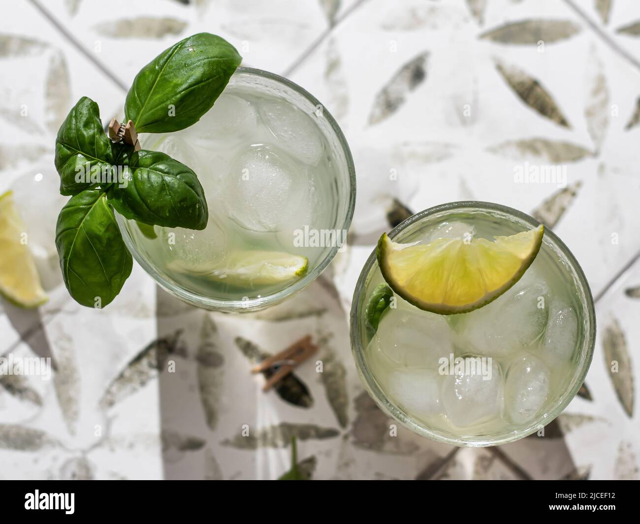 Two margarita cocktails with lime and basil on printed tile. Horisontal ...