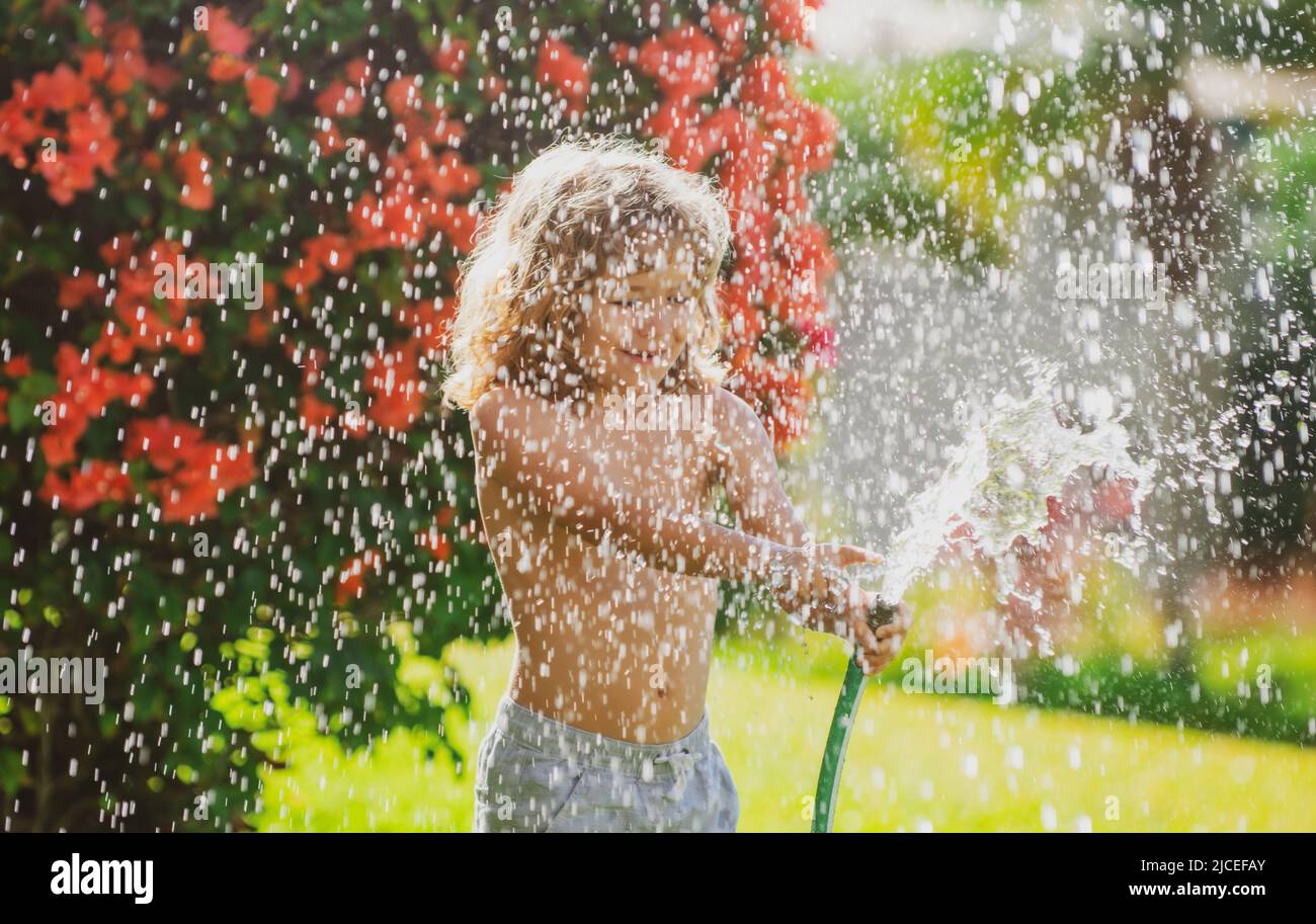 Kids play with water garden hose in yard. Outdoor children summer fun ...