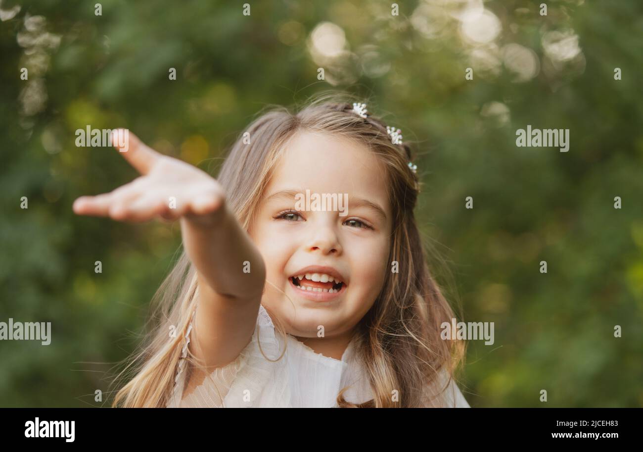 Cute child girl need help and pulling hand arm reach out to camera ...