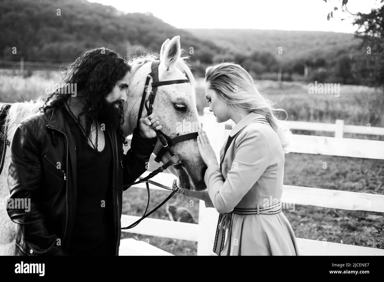Couple man and woman walking on a ranch with thoroughbred horse ...