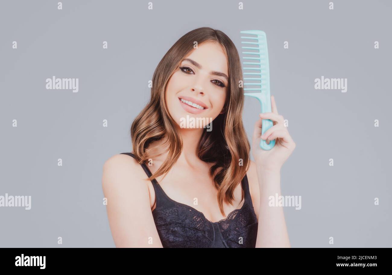 Portrait of beautiful smiling woman combing her hair, smiling. Female ...