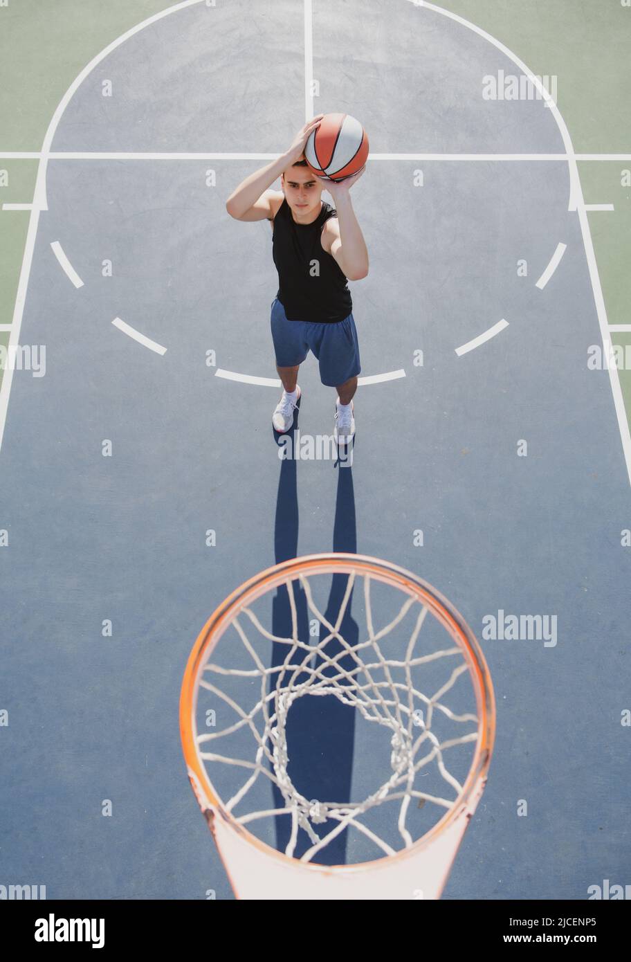 Basketball player shooting ball in hoop outdoor court. Urban youth game ...
