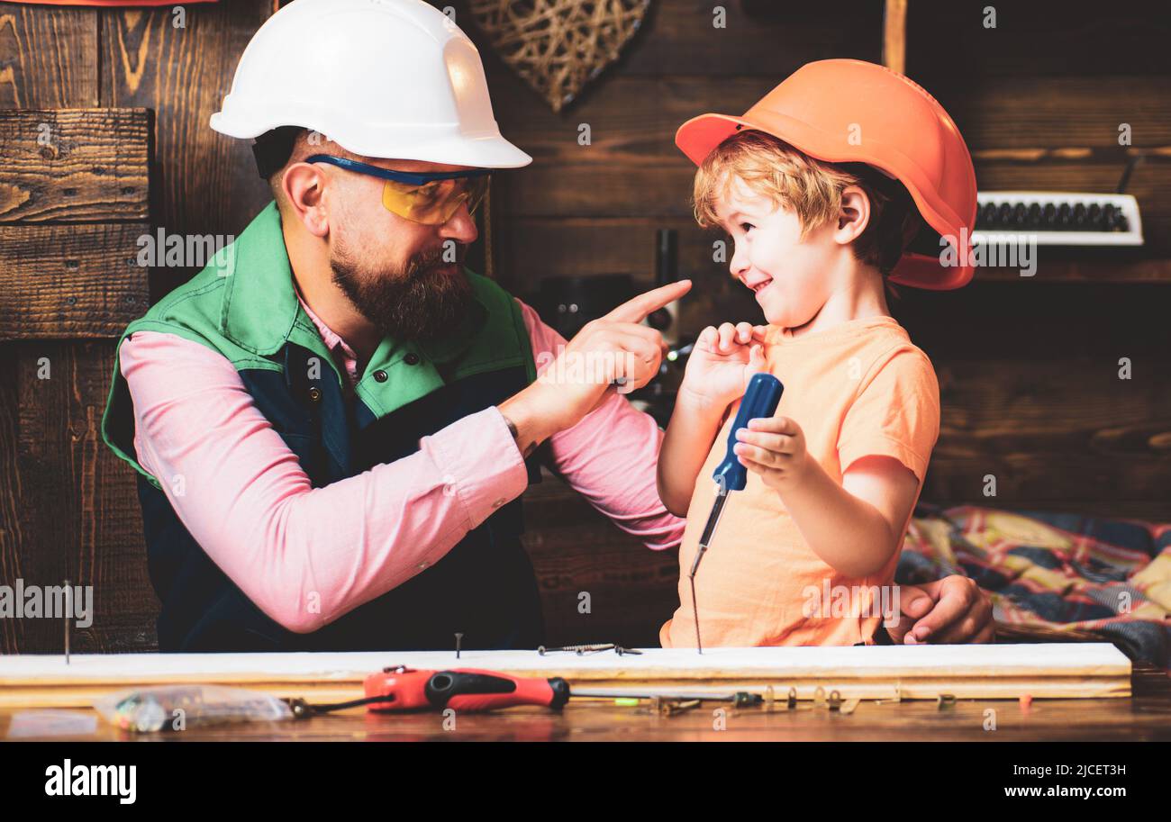 Tools construction. Father teaching little son to use carpenter tools ...