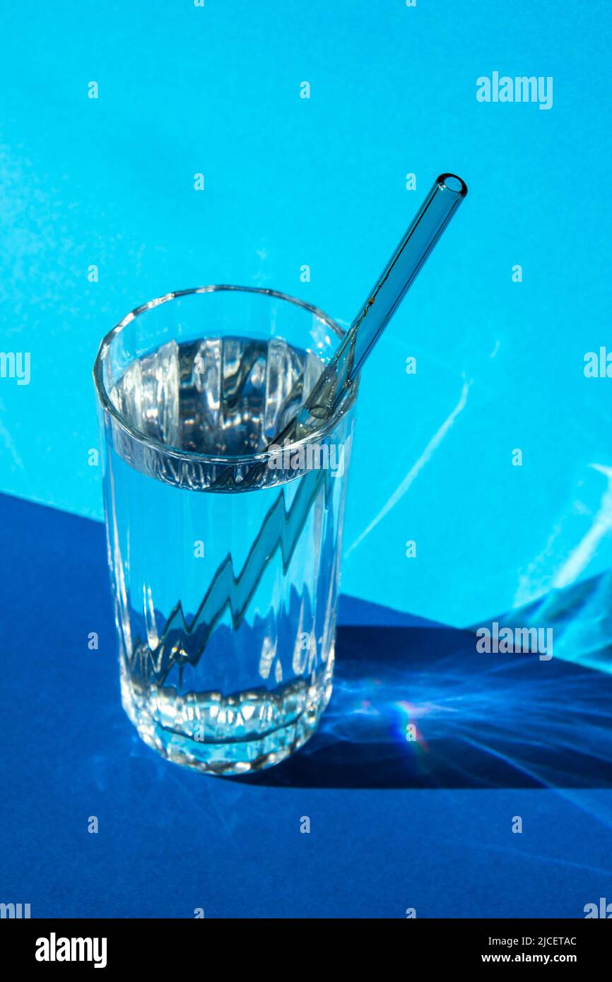 Reusable glass Straws in Glass with water on blue background Eco ...