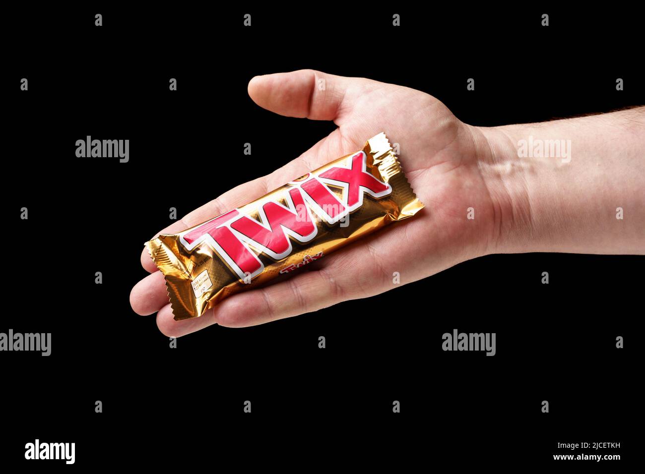A man offers a Twix chocolate bar, hand holding a chocolate bar close ...