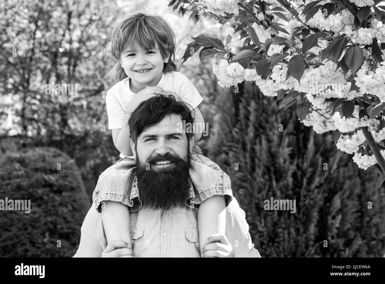 Father and son. Happy father giving shoulder ride on his shoulders in ...