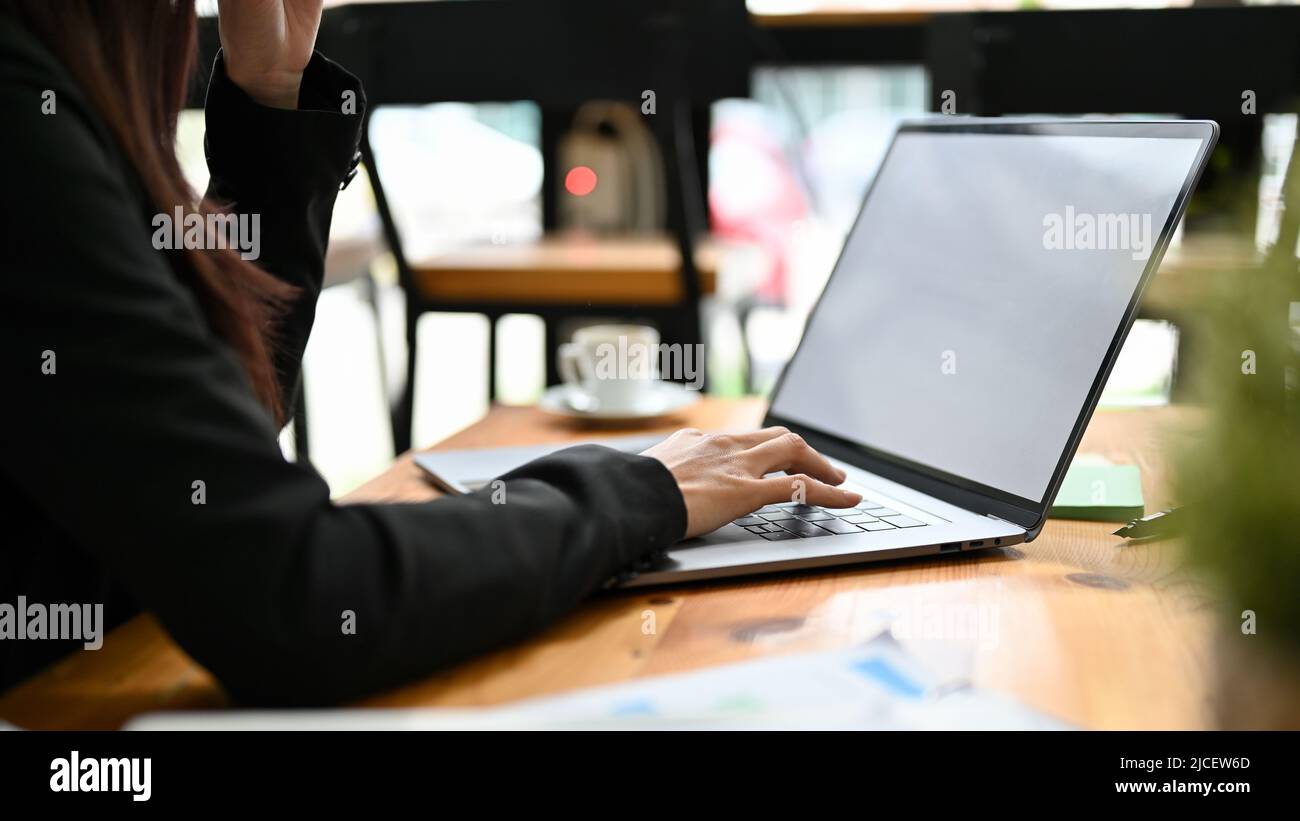 Cropped shot, Businesswoman in black suit remote working in the coffee ...