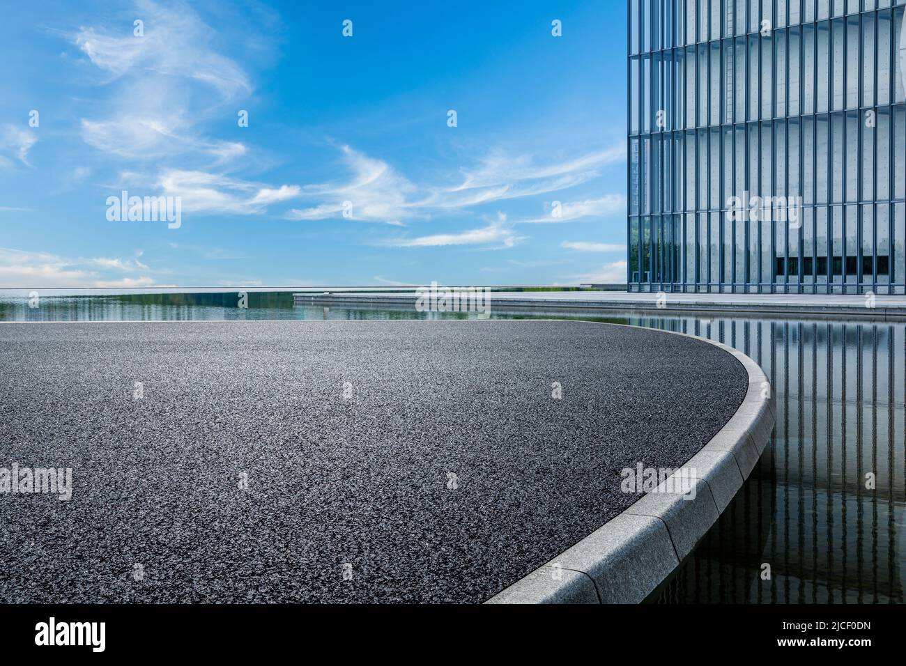 Asphalt road platform and glass wall building with sky cloud background ...