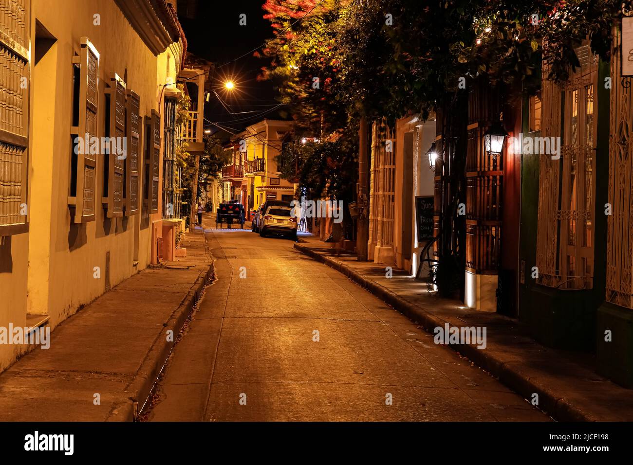 Iluminated empty street at night with colonial buildings in Cartagena ...