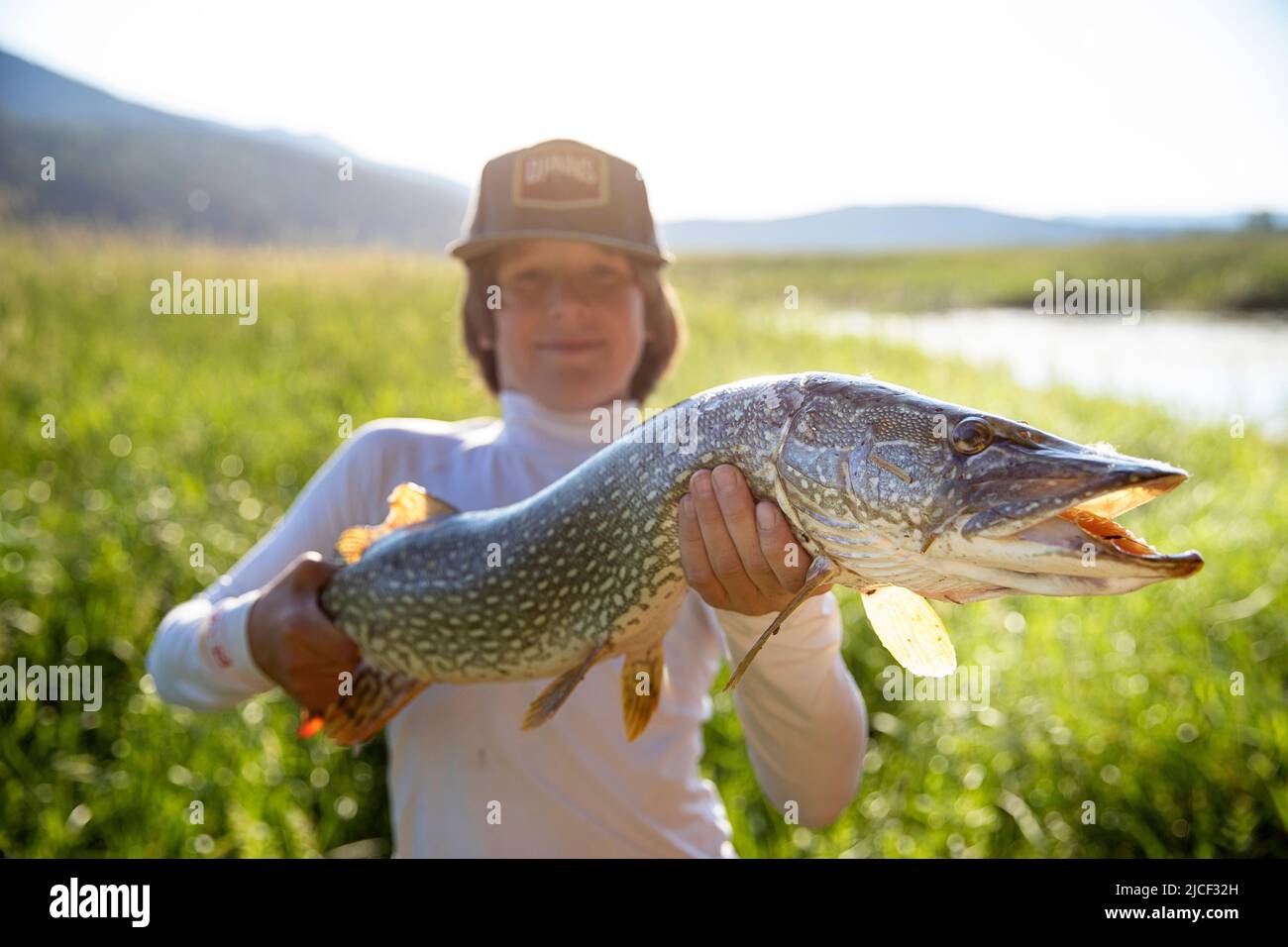 Fisherman with his catch, a giant pike fish that he caught in summer ...
