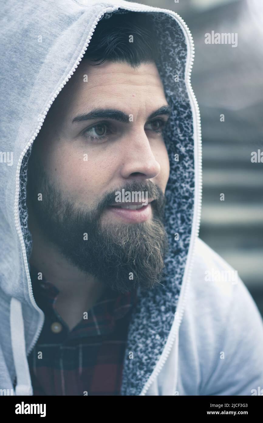 Close up on full beard young man with grey hoodie on head. Hip hop ...