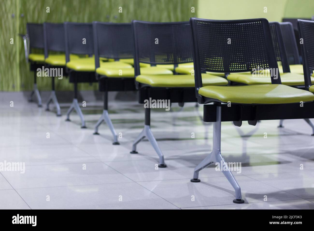 Angle perspective of rows of green chairs with perfect alignment on ...