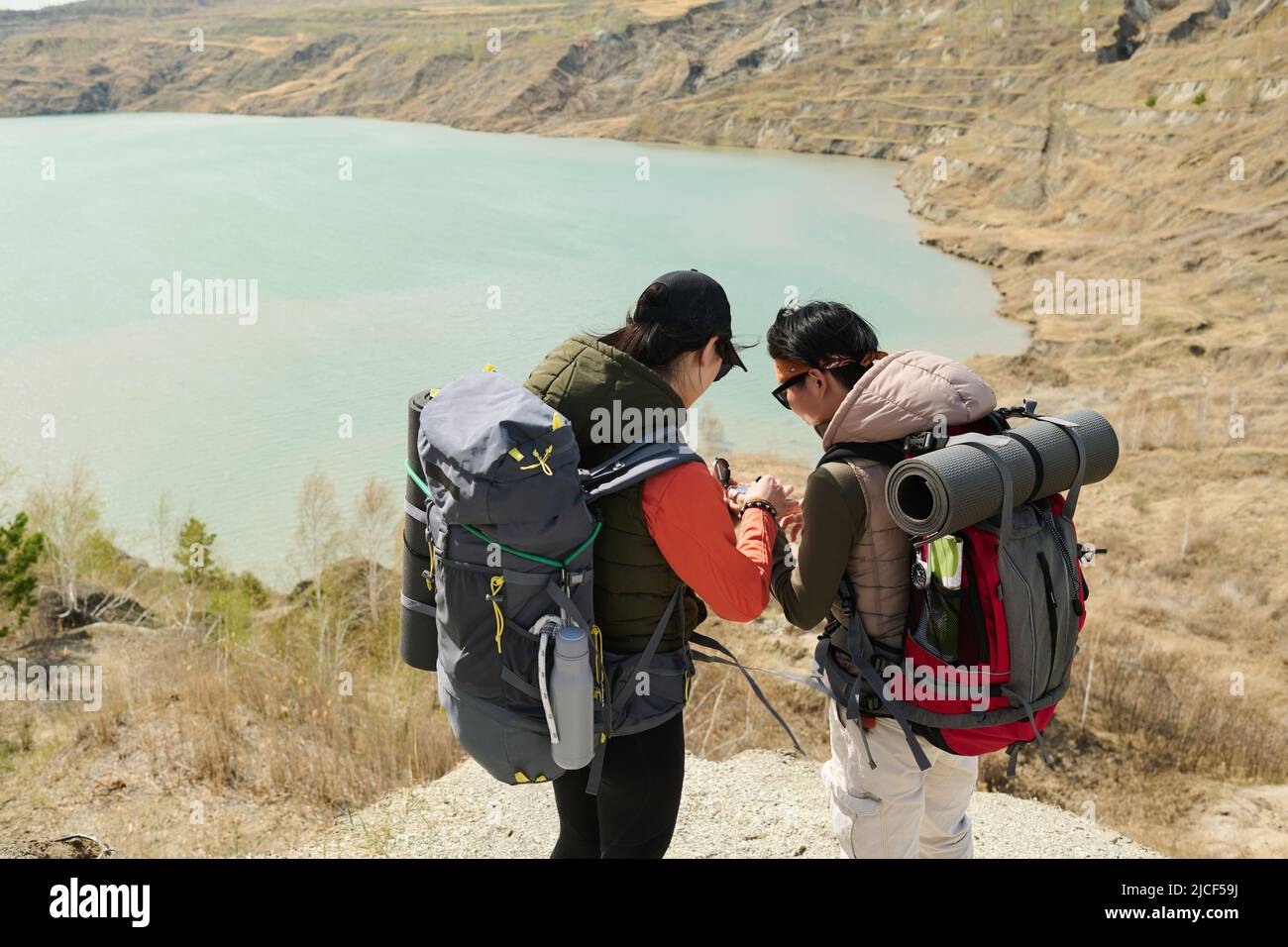 Rear view high angle of young Asian women wearing backpacks hiking ...