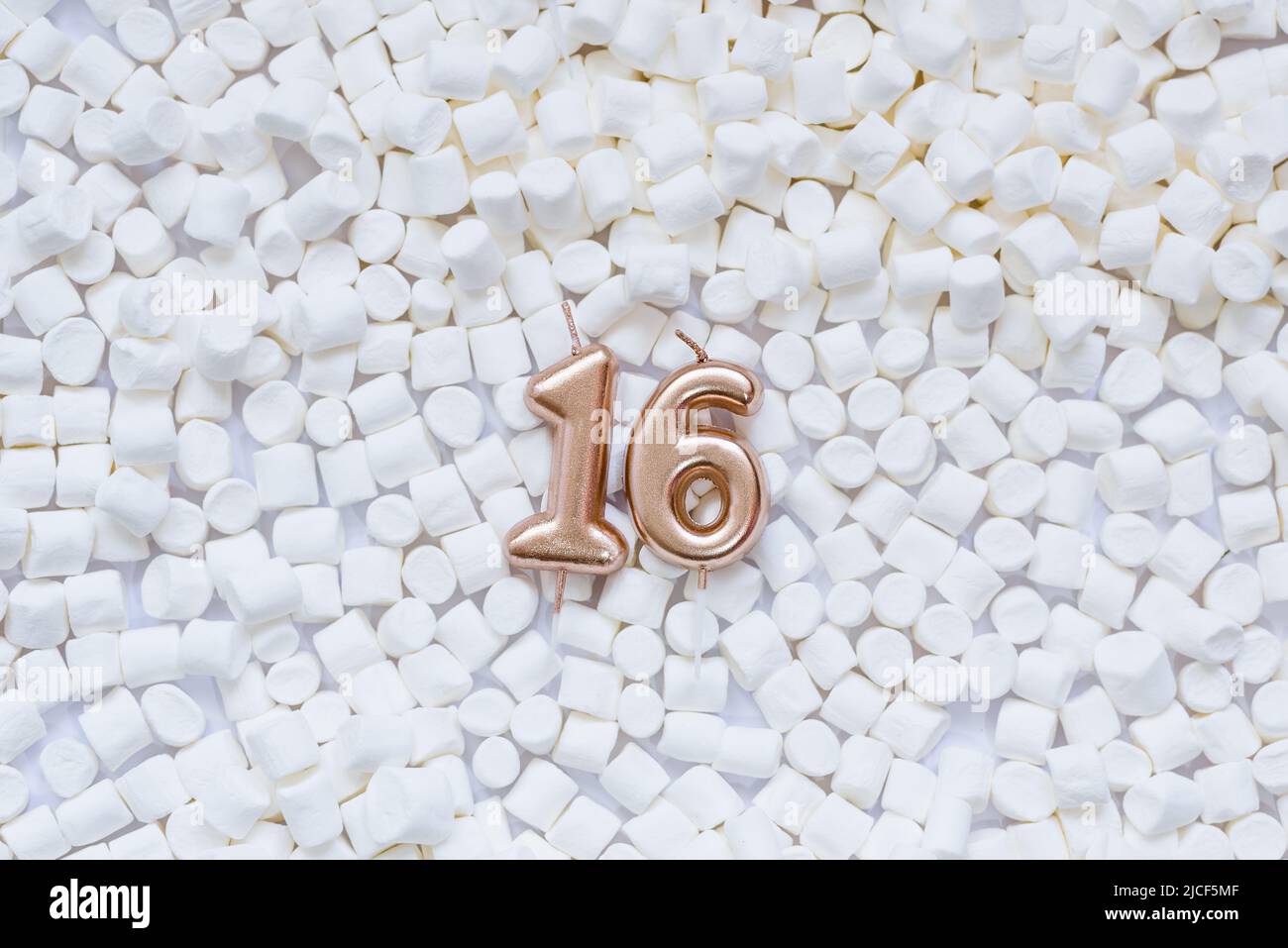 Number 16 golden celebration birthday candle on Background with white ...